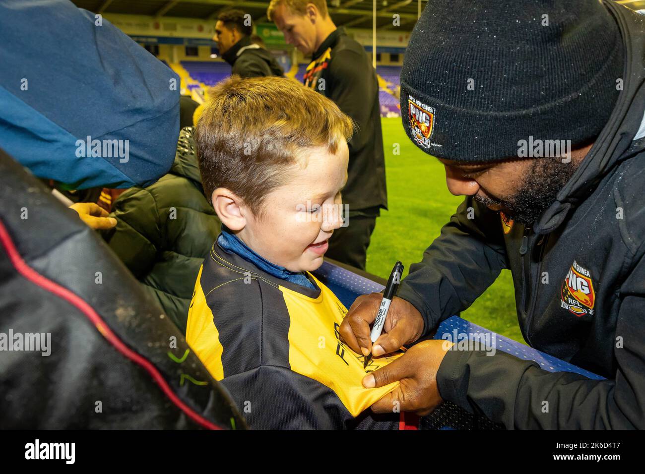 A player from the Papua New Guinea Rugby League squad signs a child's ...