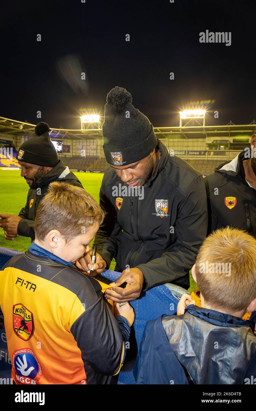 A player from the Papua New Guinea Rugby League squad signs a child's ...