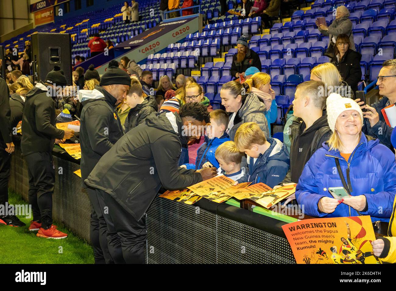 A player from the Papua New Guinea Rugby League squad signs a poster ...