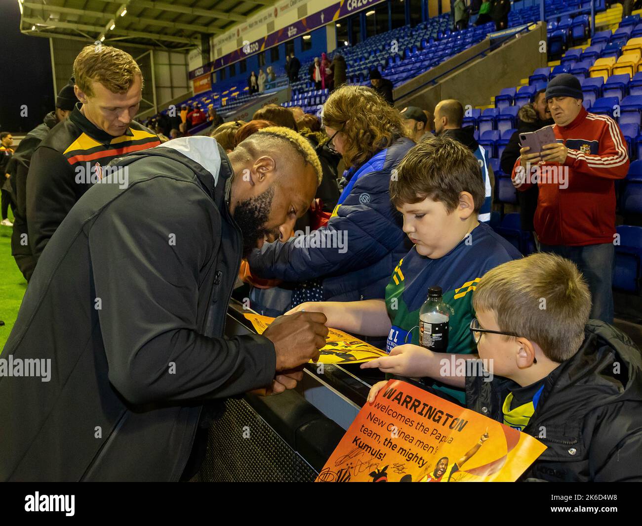 A player from the Papua New Guinea Rugby League squad signs a poster ...
