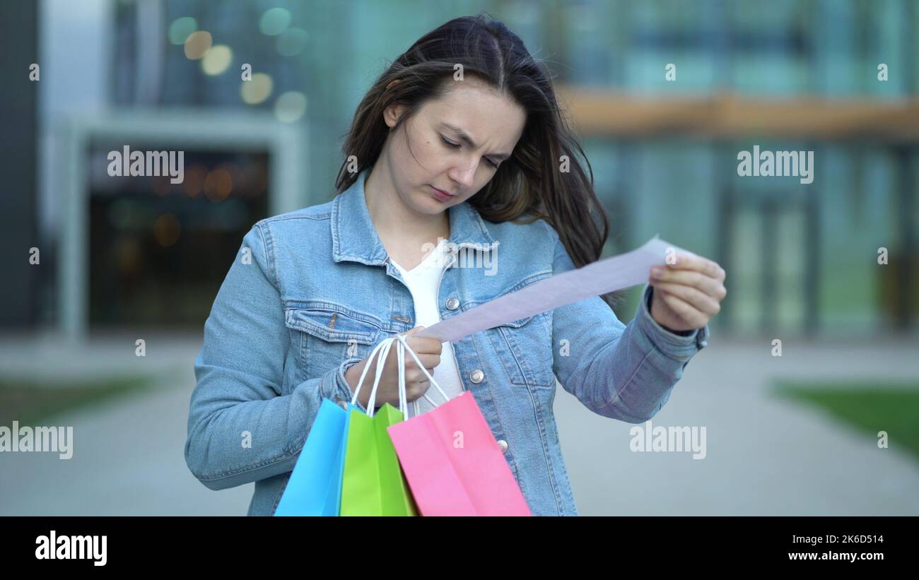 A girl with a cash receipt in her hands on the background of a shopping ...