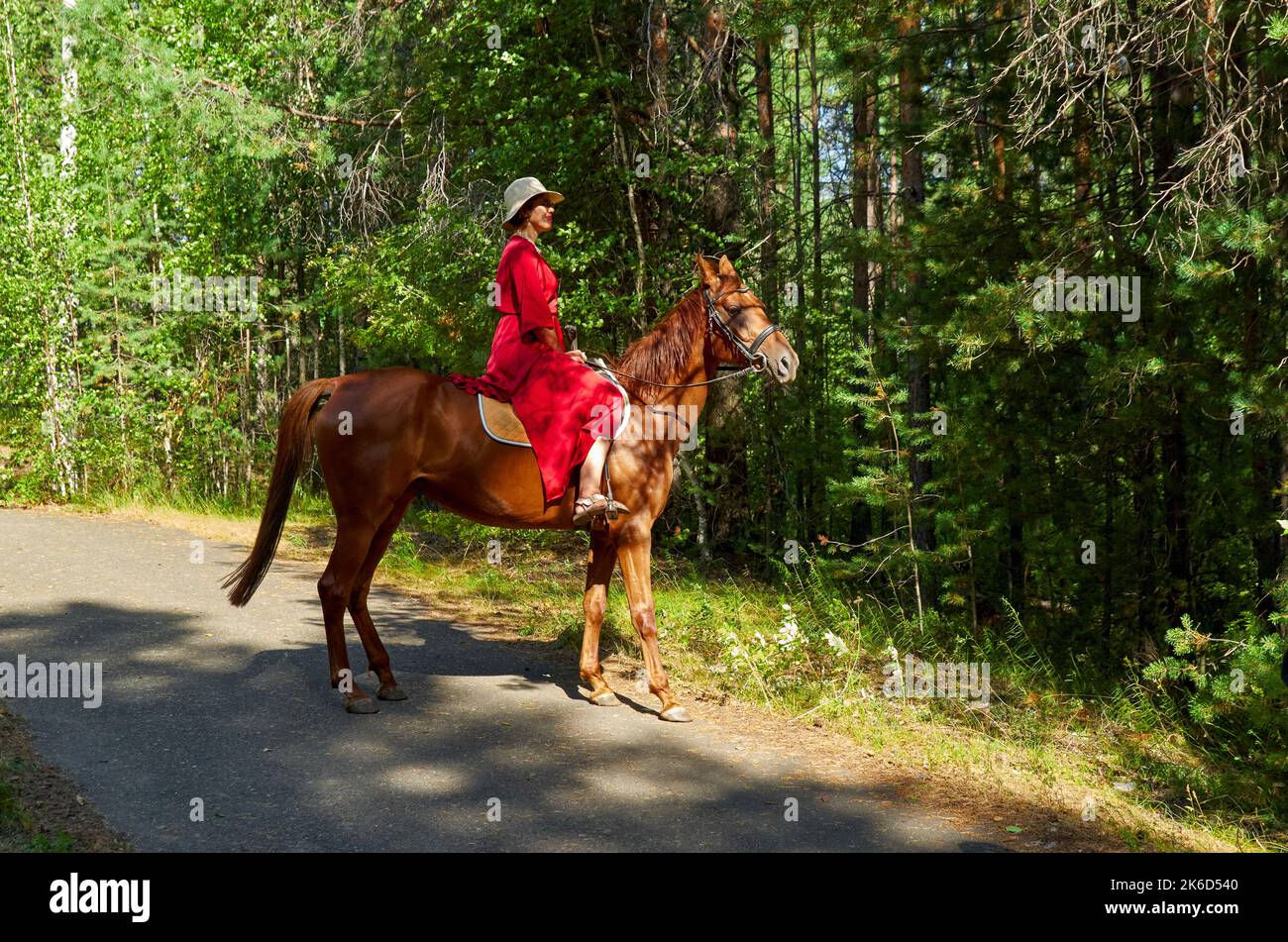 Woman in red dress riding horse hi-res stock photography and images - Alamy