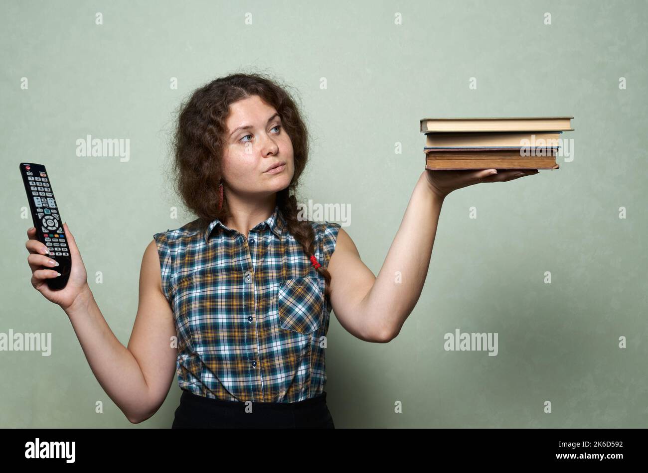 Book vs television. A woman makes a choice between books in one of her ...