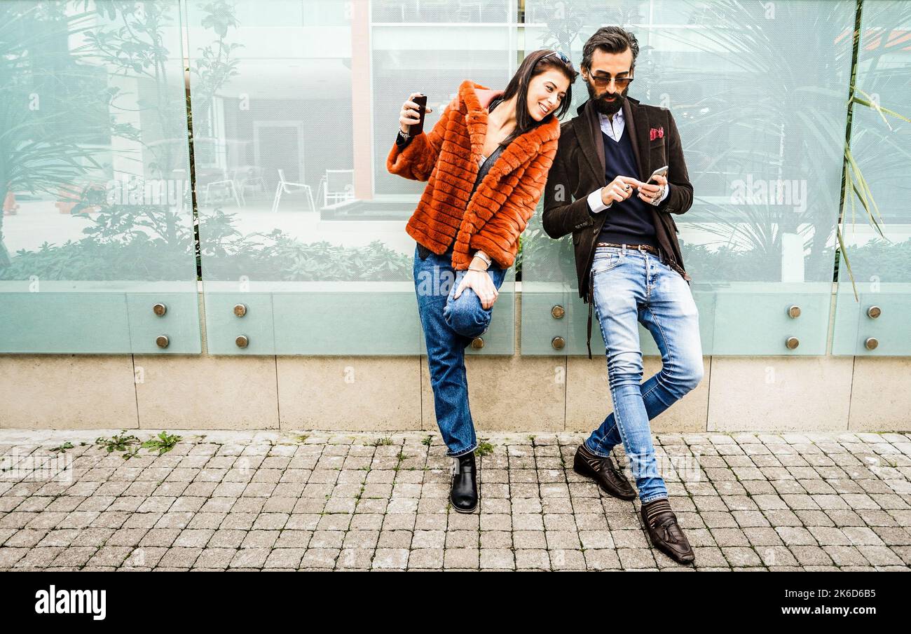 Happy hipster couple having fun with mobile smart phone at outdoors ...