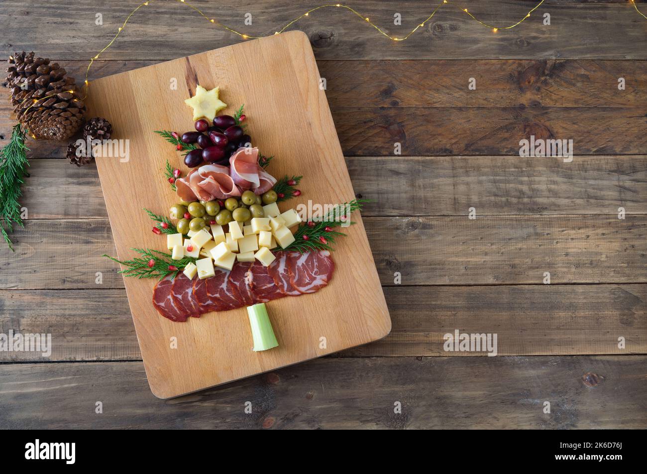 Christmas tree-shaped cheese and charcuterie appetizer board with ...