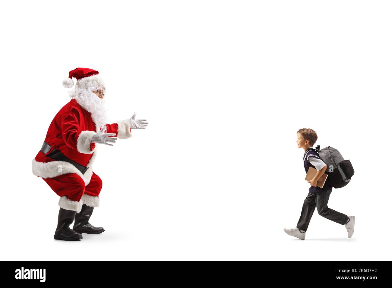 Schoolboy running to hug santa claus isolated on white background Stock ...
