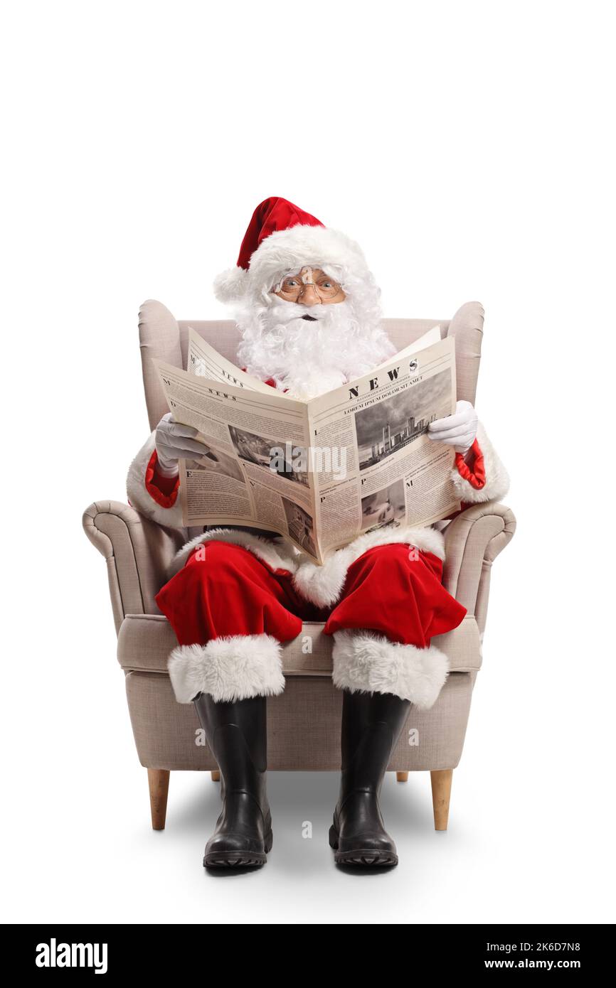 Santa claus sitting in armchair and reading newspaper isolated on white ...