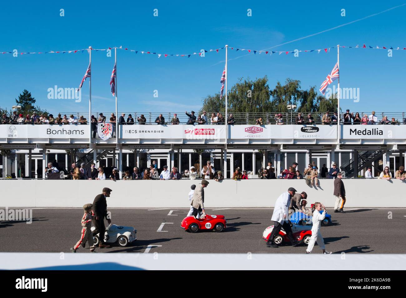 Parents and their children pushing their Austin J40 pedal cars to the ...