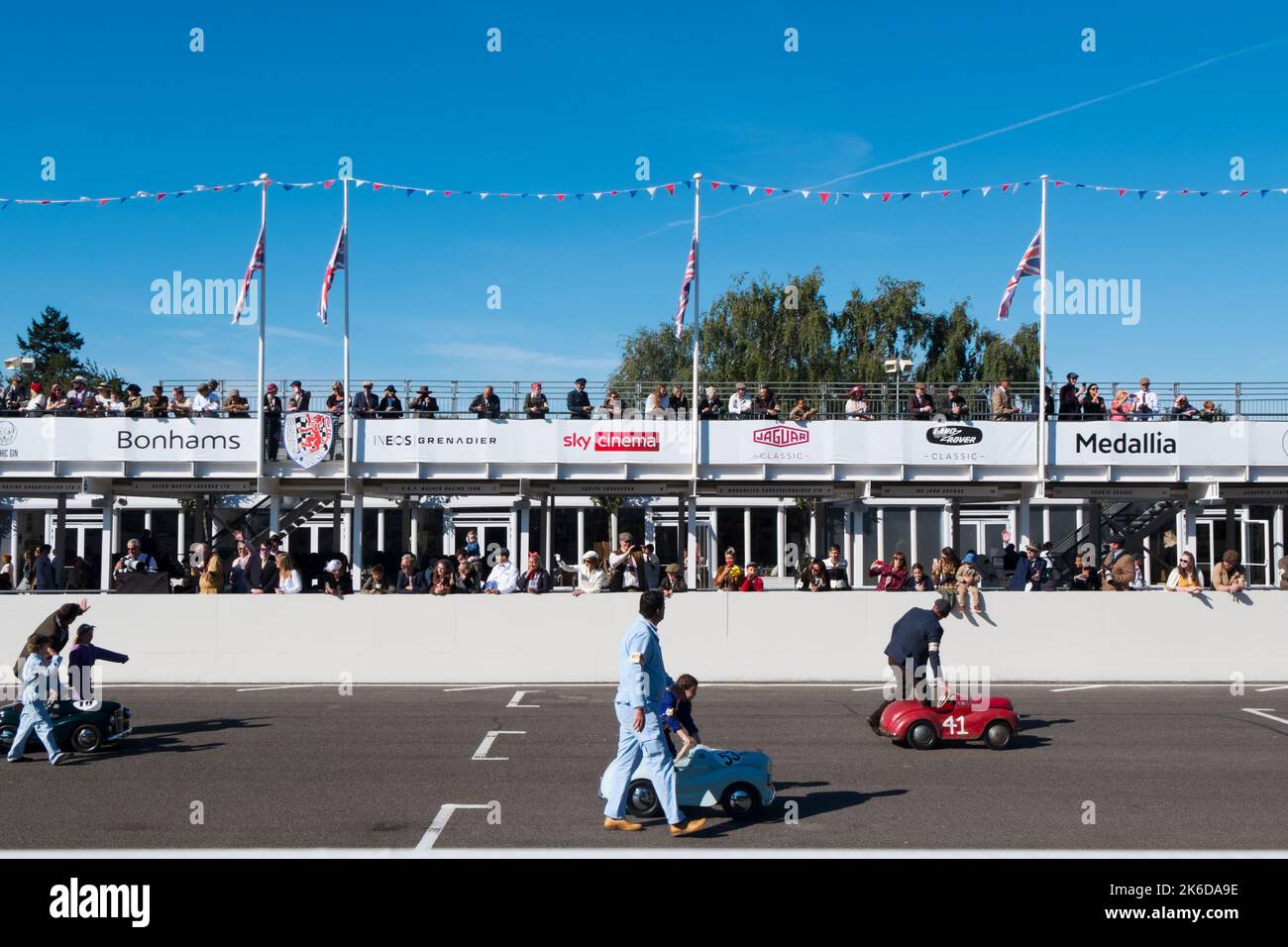 Parents and their children pushing their Austin J40 pedal cars to the ...
