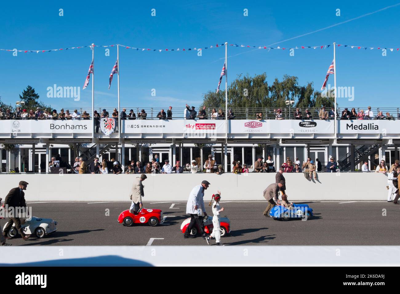 Parents and their children pushing their Austin J40 pedal cars to the ...