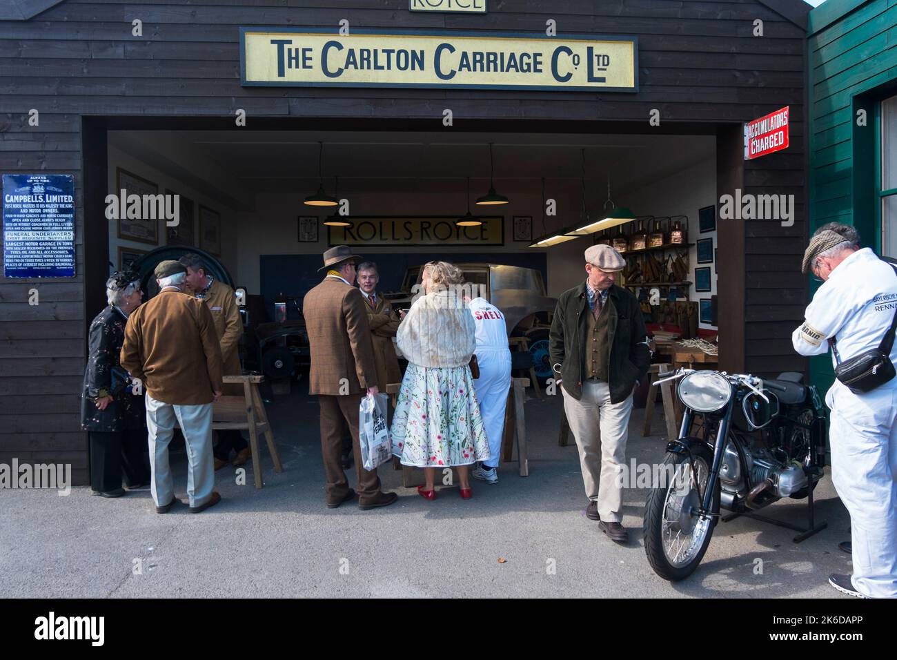 People dressed in period clothes looking at Rolls Royce garage The ...