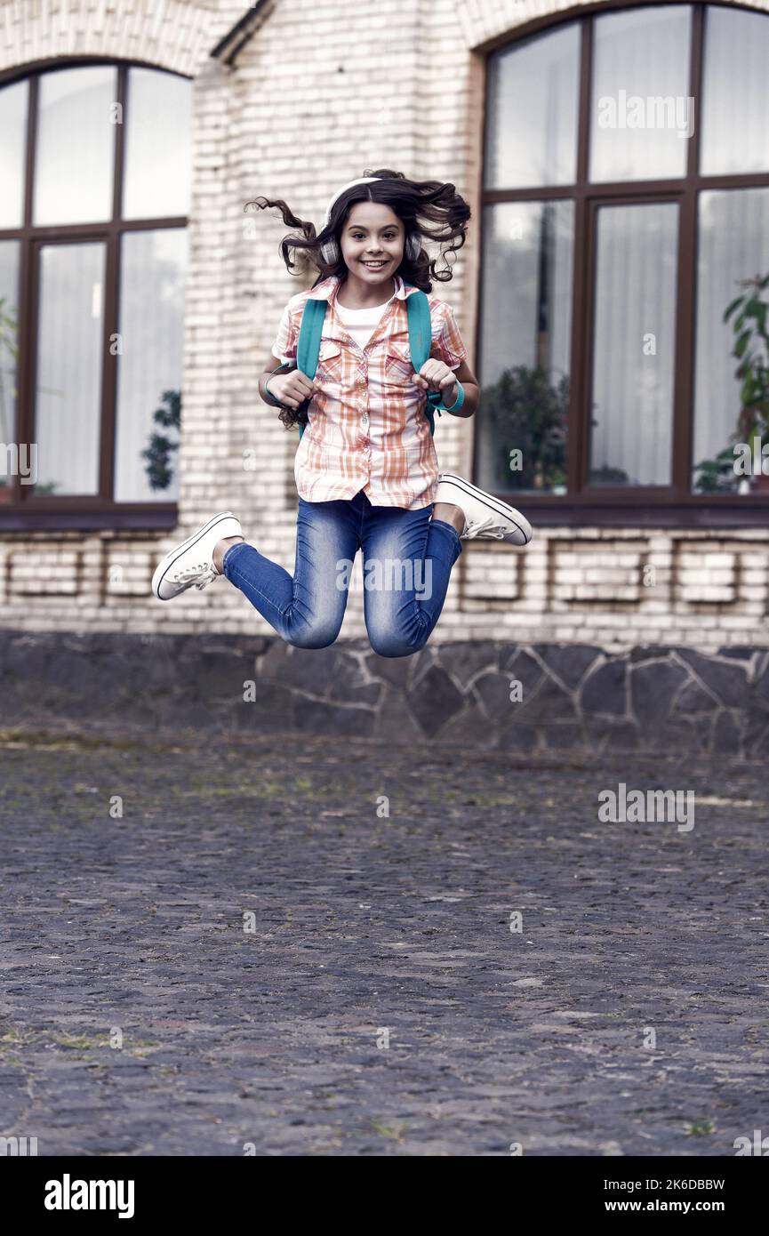 Happy childrens day. Energetic child jump in schoolyard. School ...
