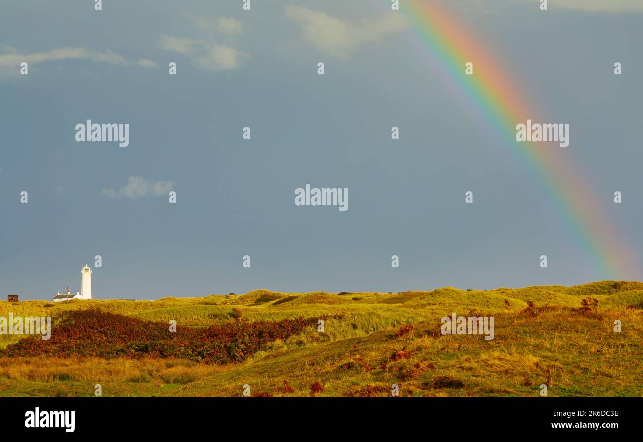 A lighthouse at the South Walney Nature Reserve and a rainbow Stock ...