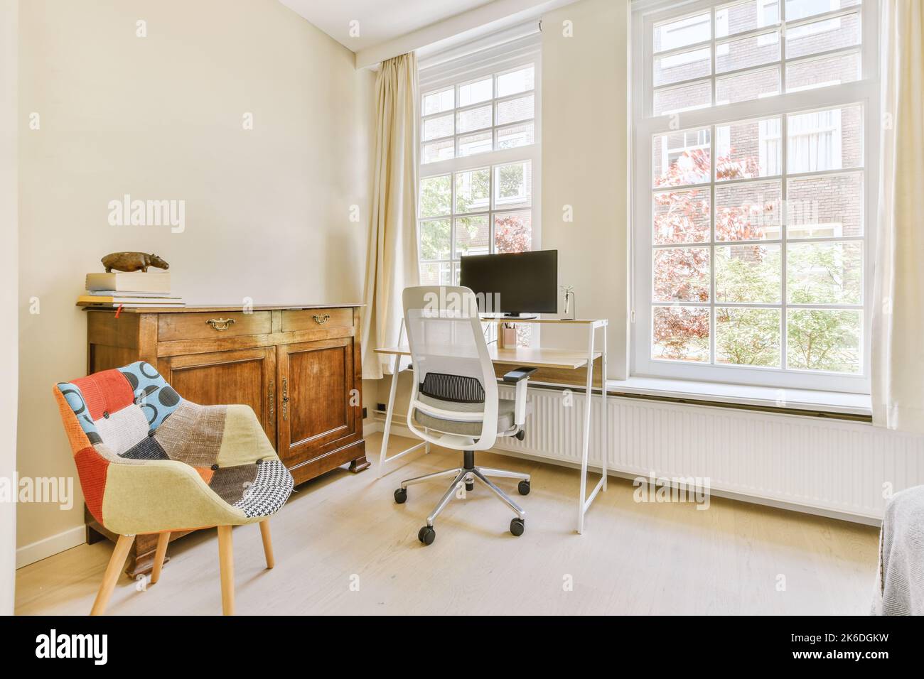 Comfortable chair placed near desk with computer monitors and ...
