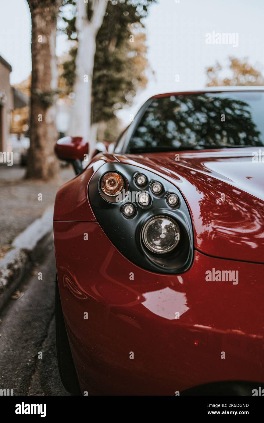 A vertical closeup shot of a modern red car headlight outdoors Stock ...