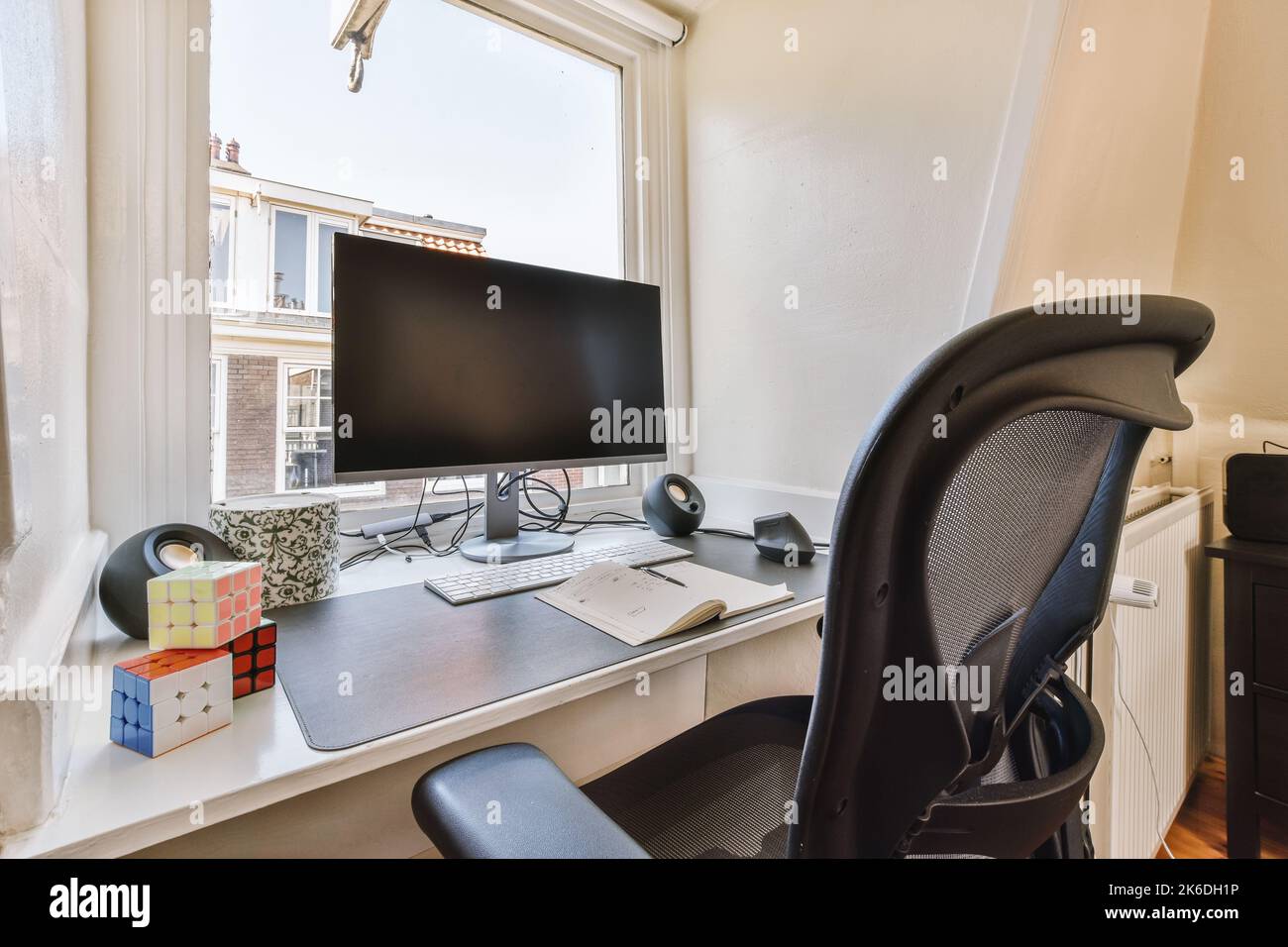 Comfortable chair placed near desk with computer monitors and ...