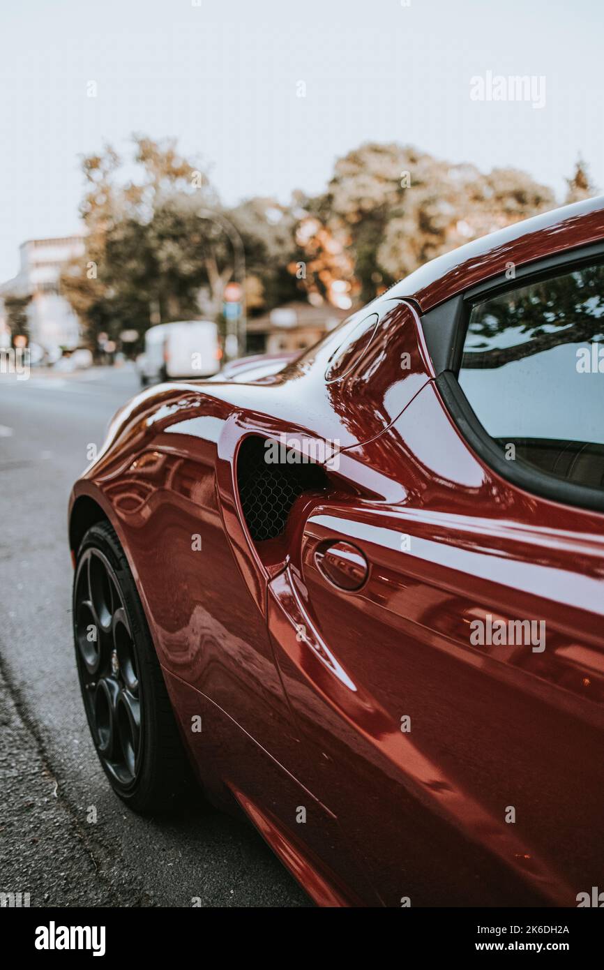 A vertical side view of a modern red car parked outdoors Stock Photo ...