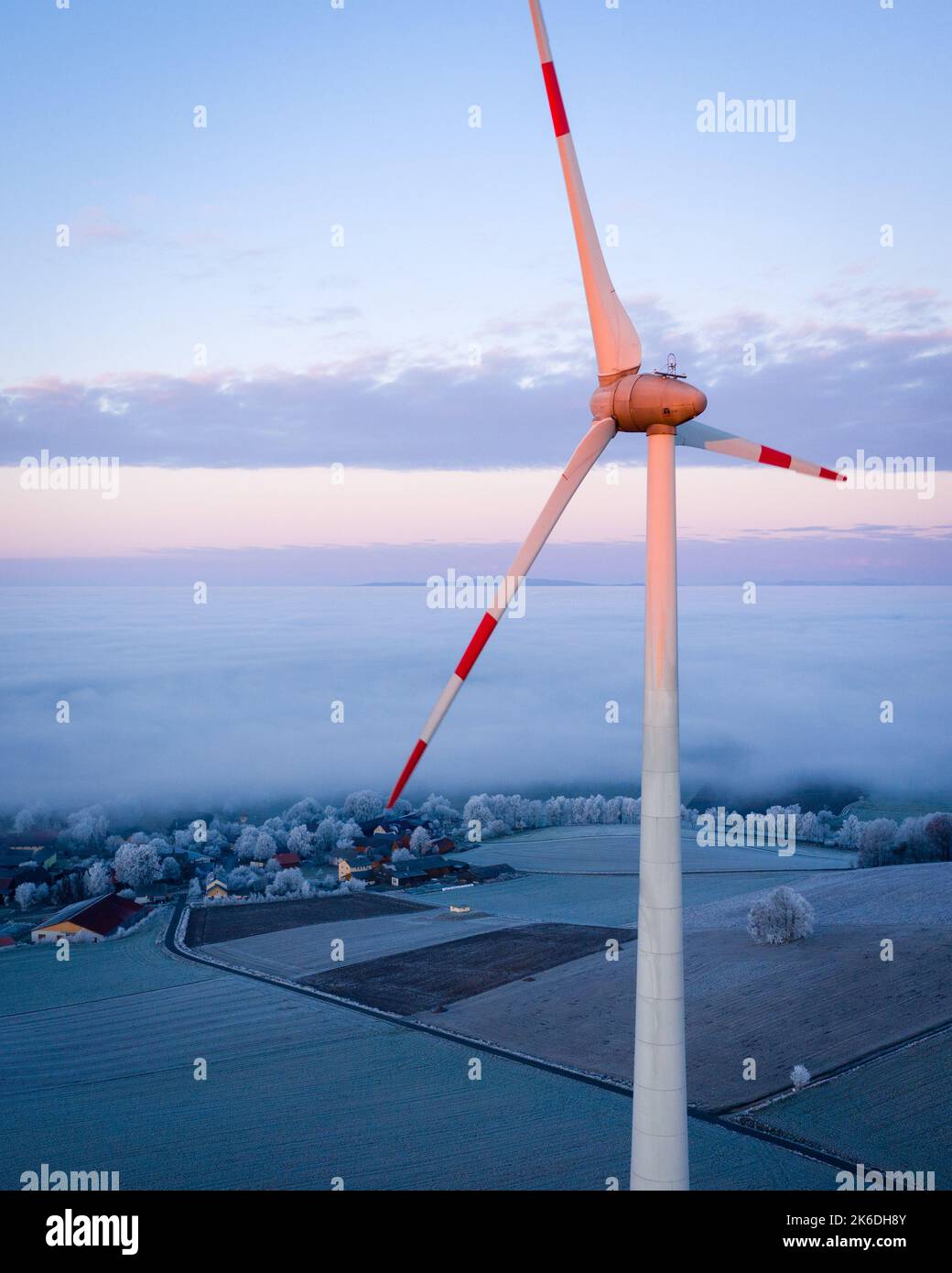 A vertical closeup of a big wind turbine on a breathtaking scenery of a ...