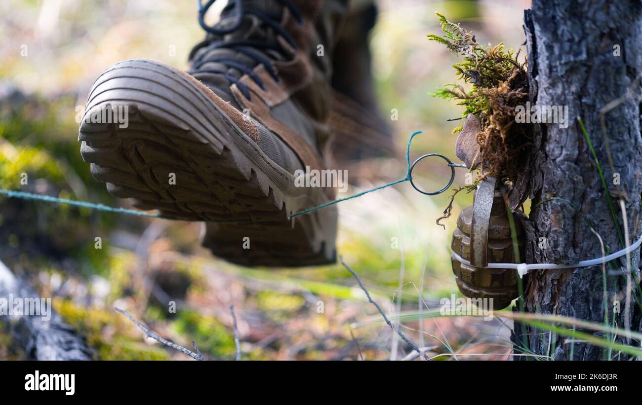 Soldier steps on a mine trap. The soldier's boot rips off the wire and ...