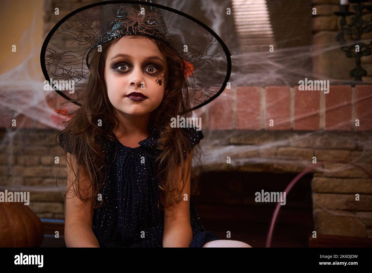 Happy Halloween. Beautiful little girl in witch costume and wizard hat ...
