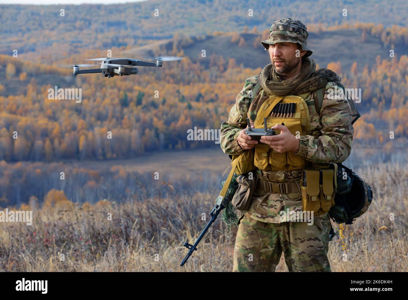 An artillery spotter or military observer launches a drone into the sky for reconnaissance in ...