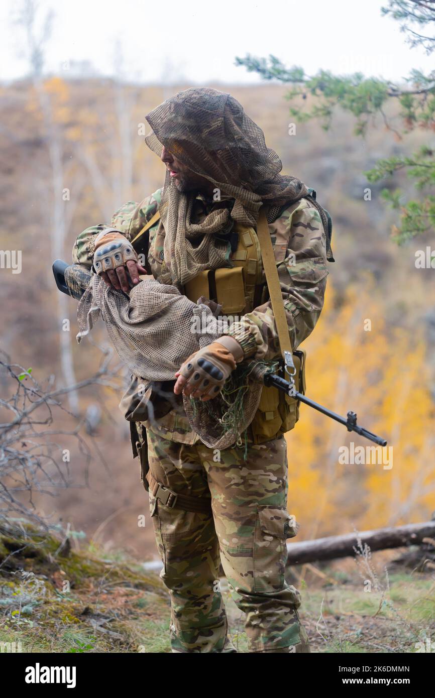 Vertical photo of a mercenary military sniper during a sabotage ...