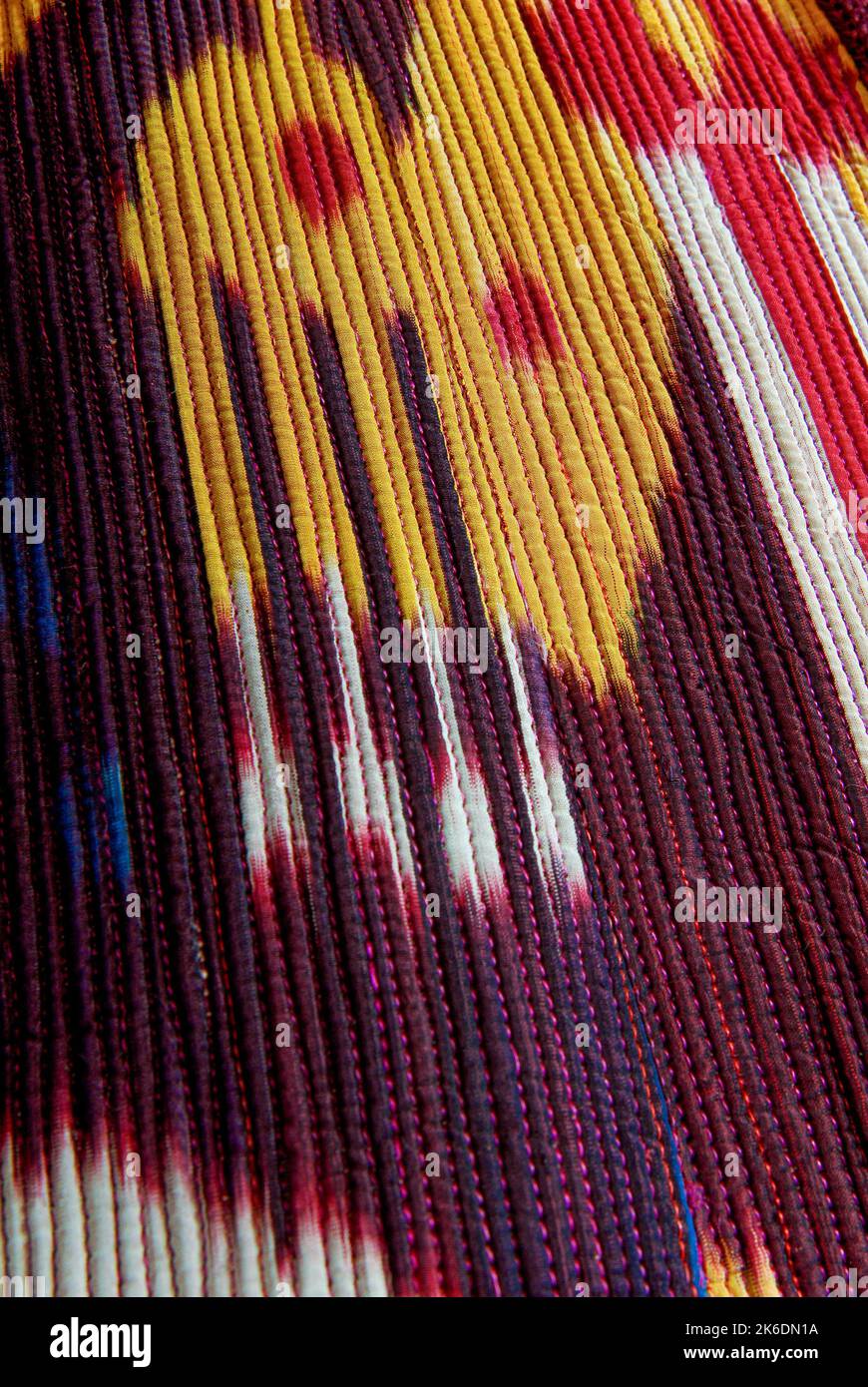 A vertical closeup shot of red and yellow carpet seams with designs on ...