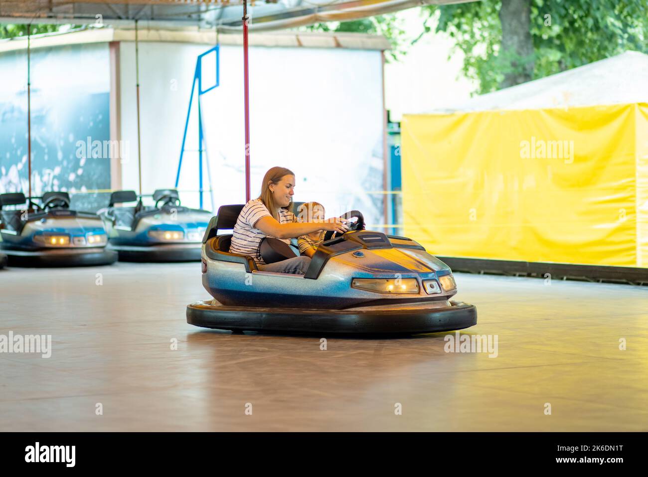 Mother and son having ride in the bumper car at the amusement park ...