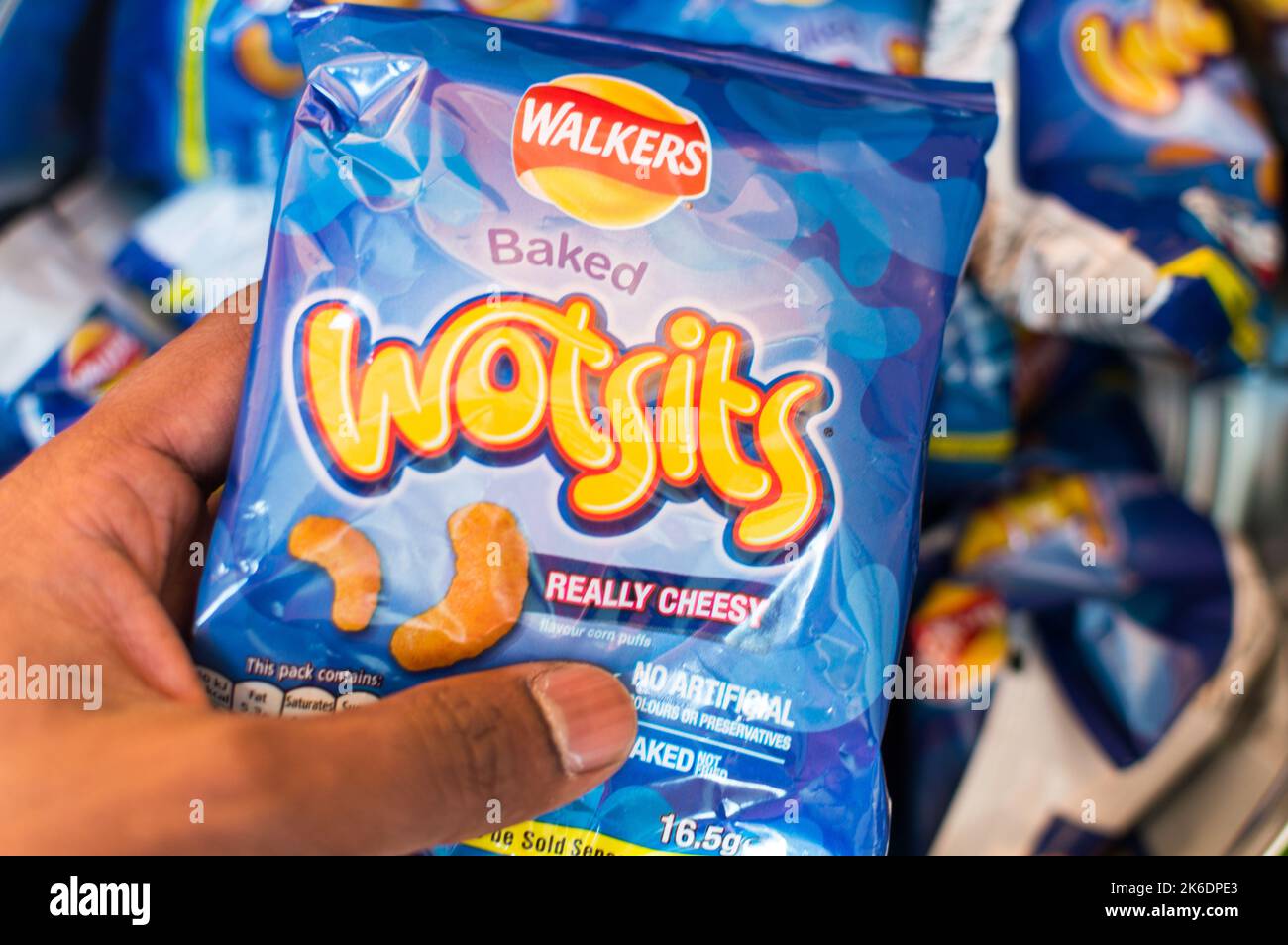Adult male picking up Wotsits snacks from a snack shelf at home Stock ...