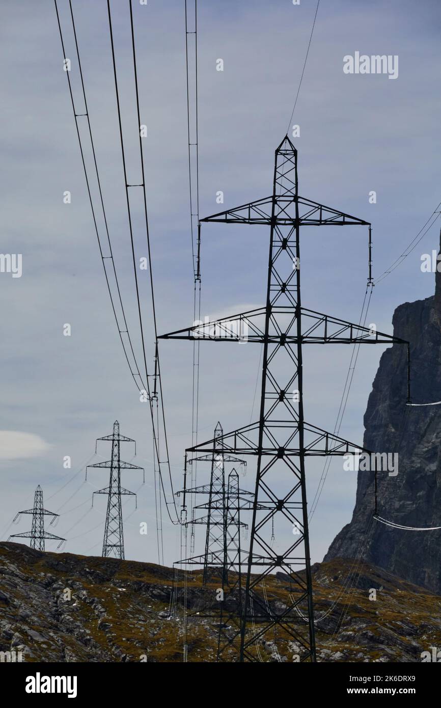 A vertical of power pylons in the mountains Stock Photo - Alamy