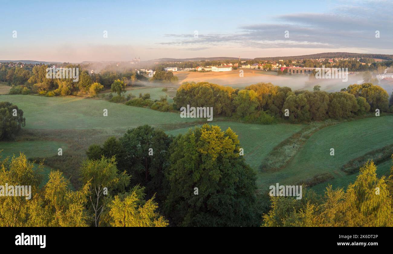 A high-angle of Meander river stream meadows with green and yellow ...