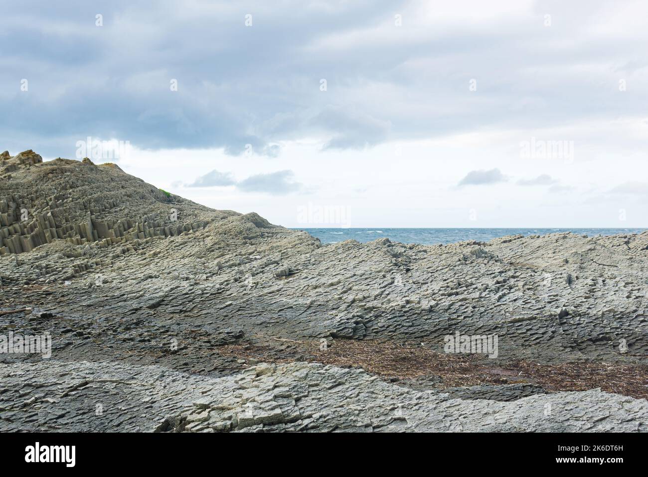 rocky seashore made of columnar granite, hardened lava, resembling ...