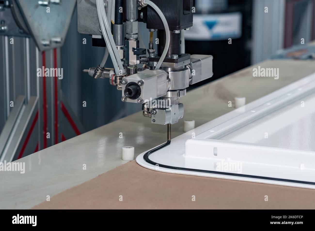 industrial robotic dosing dispenser machine applies a hardening sealant ...