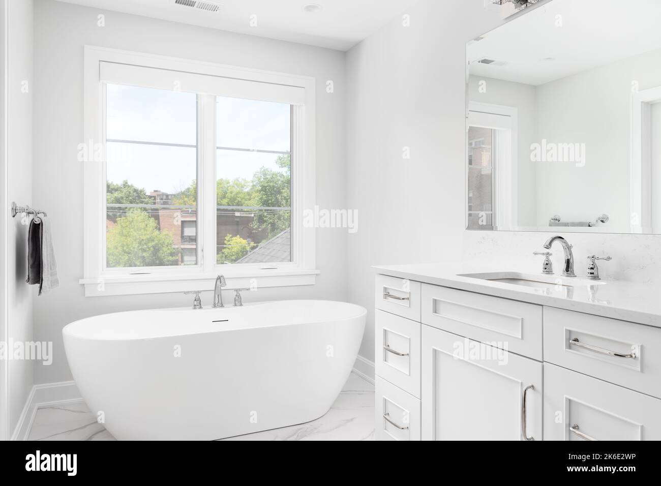 A beautiful bathroom with a white vanity cabinet, chrome faucet, and a ...