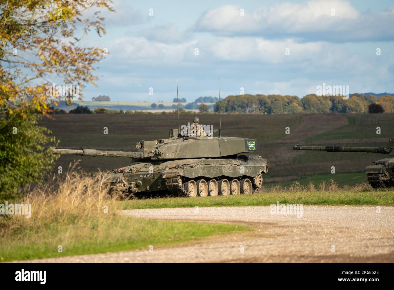 British army Challenger II 2 FV4034 main battle tank in action crossing open grass fields, on a ...