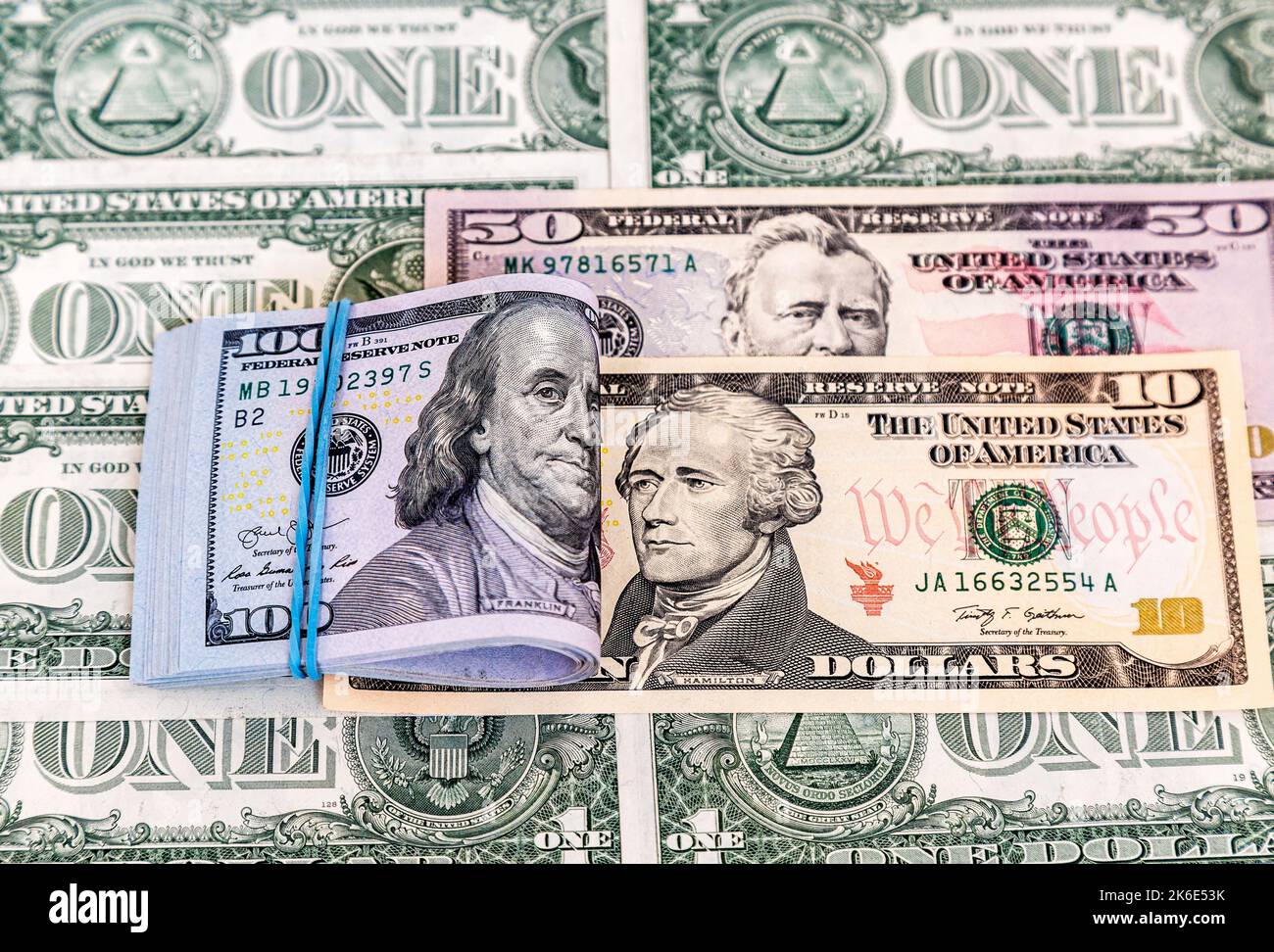 Folded american dollars banknotes wrapped by rubber band over dollars ...
