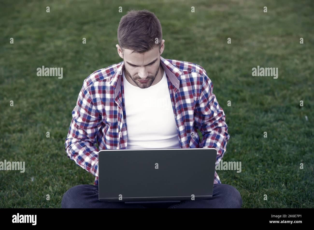 Modern technologies. Student studying on meadow. Online communications ...