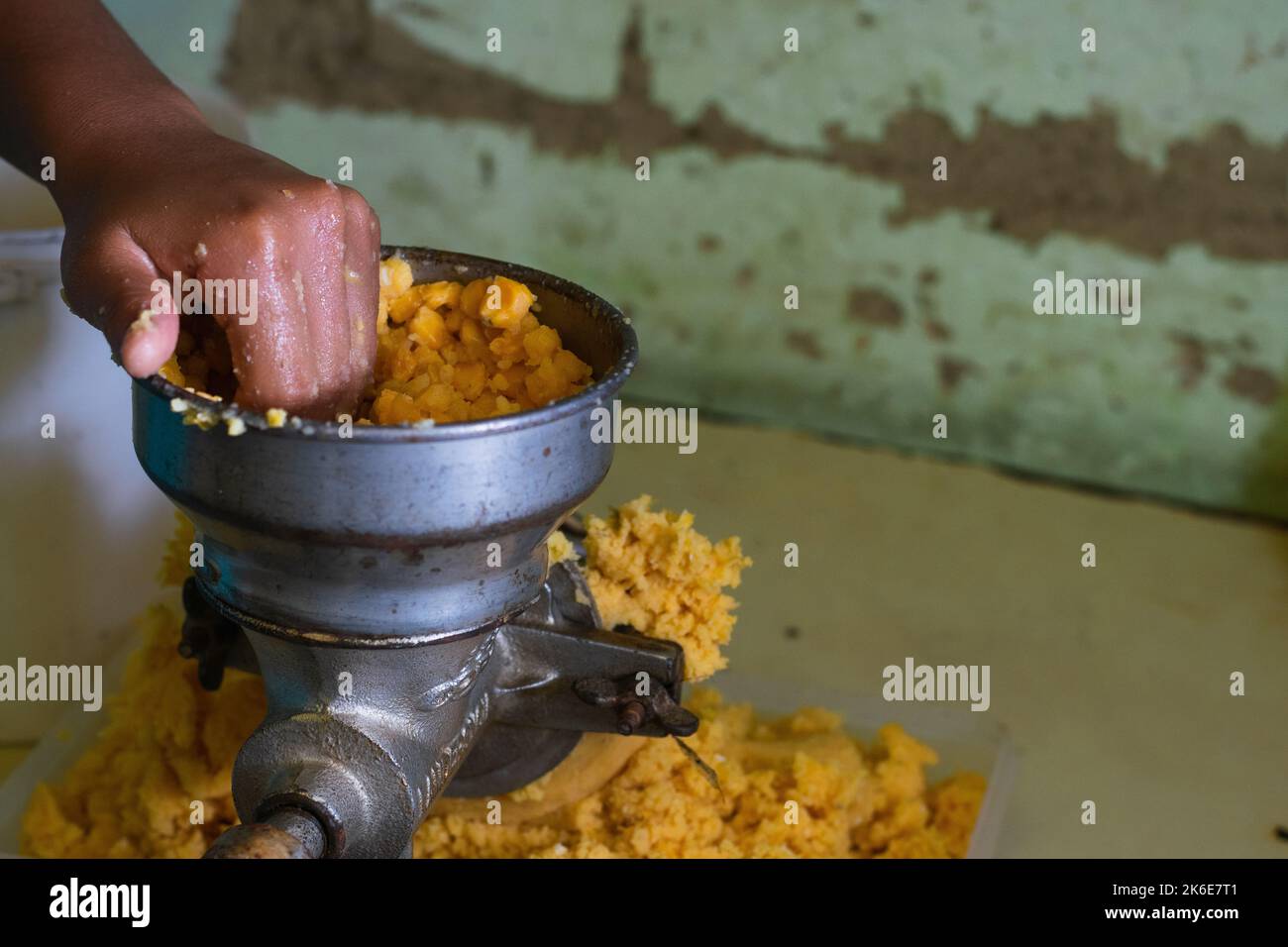 detail shot of the hand of a young latina, putting it in the hopper ...