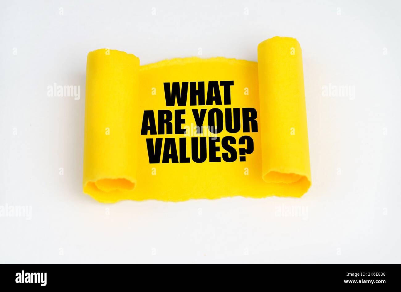 On a white surface, a yellow scroll of paper with the inscription ...