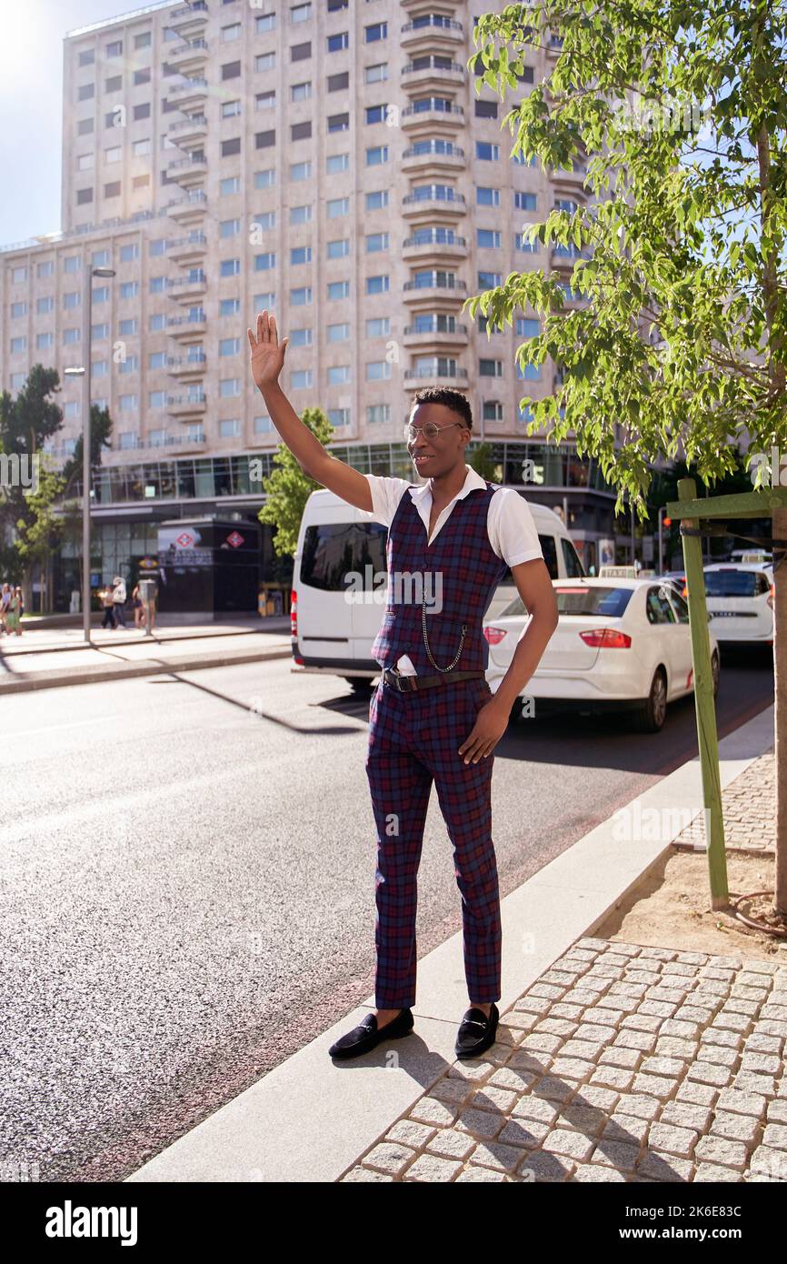 Man hailing a taxi. man raising his hand to signal for a taxi in the ...