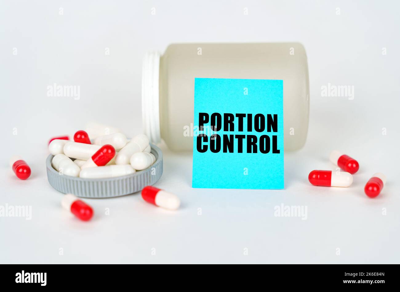 Medical concept. On a gray background, a jar, capsules and a sign with ...