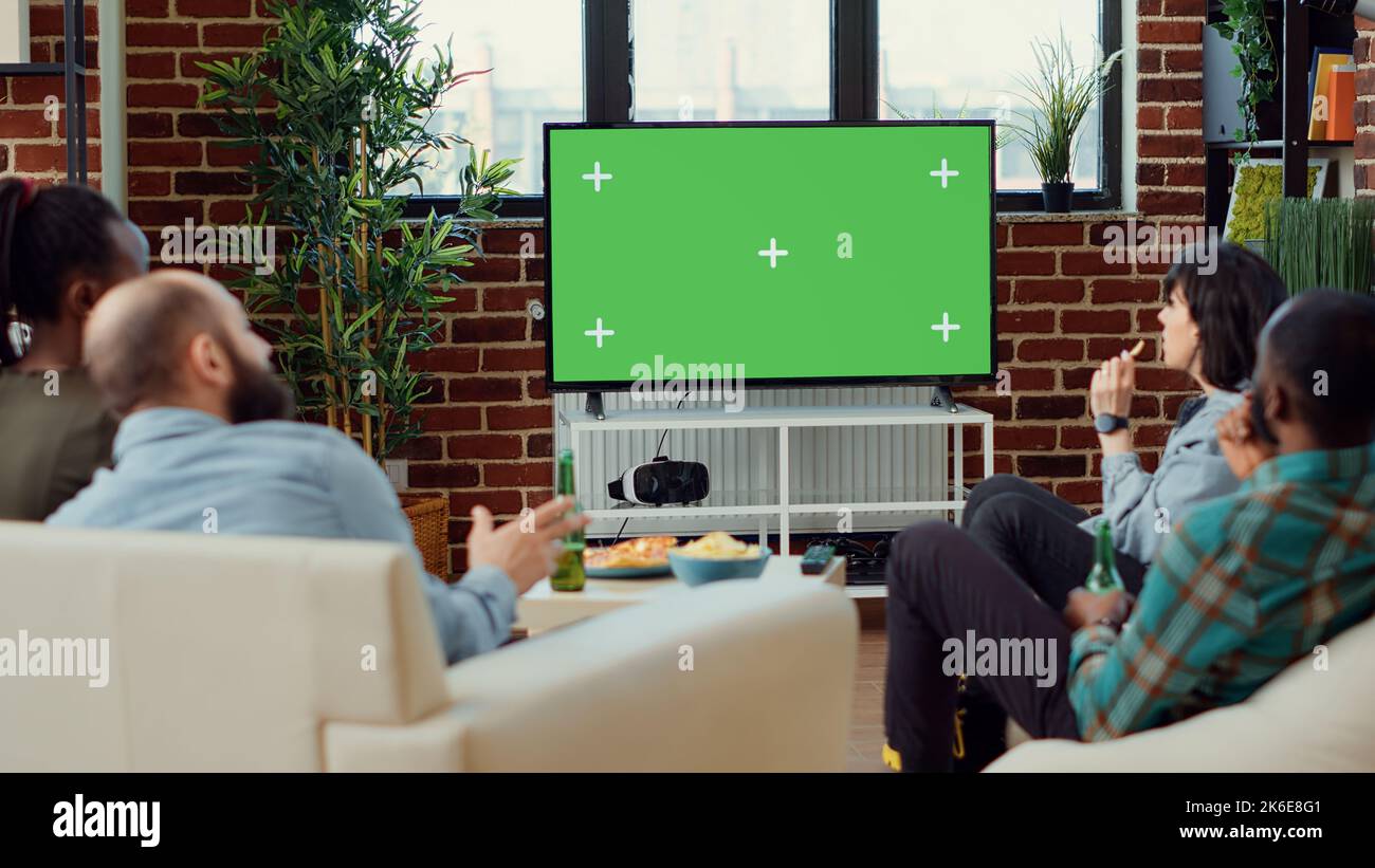Diverse people watching movie on television with greenscreen template ...