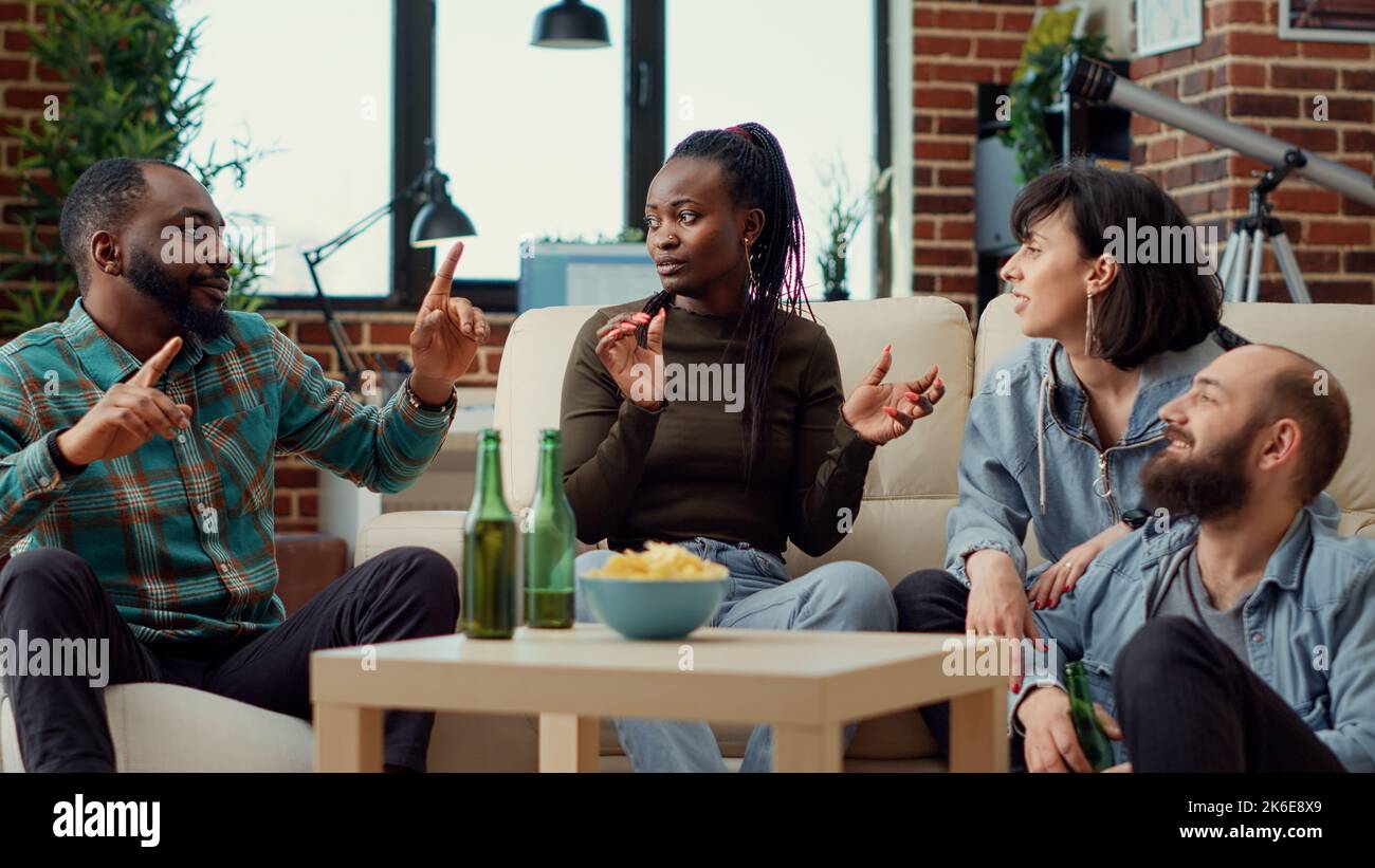 Happy people laughing and having conversation at hangout, drinking beer ...