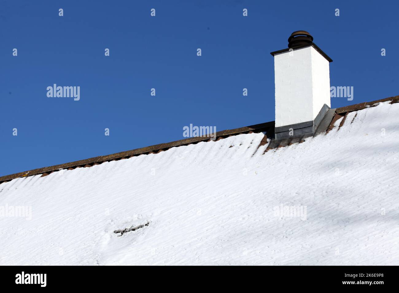 White chimney and roof with snow. A cold winter and possible lack of ...