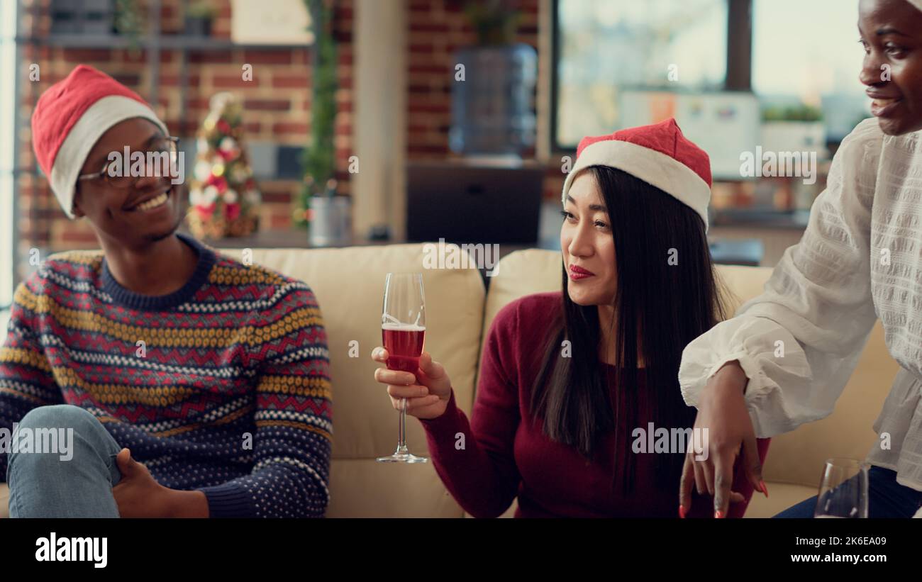 Diverse employees drinking glasses of wine at christmas party in office ...