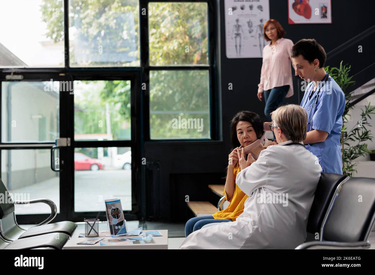 Medical assistant and medic helping senior woman with cervical neck ...
