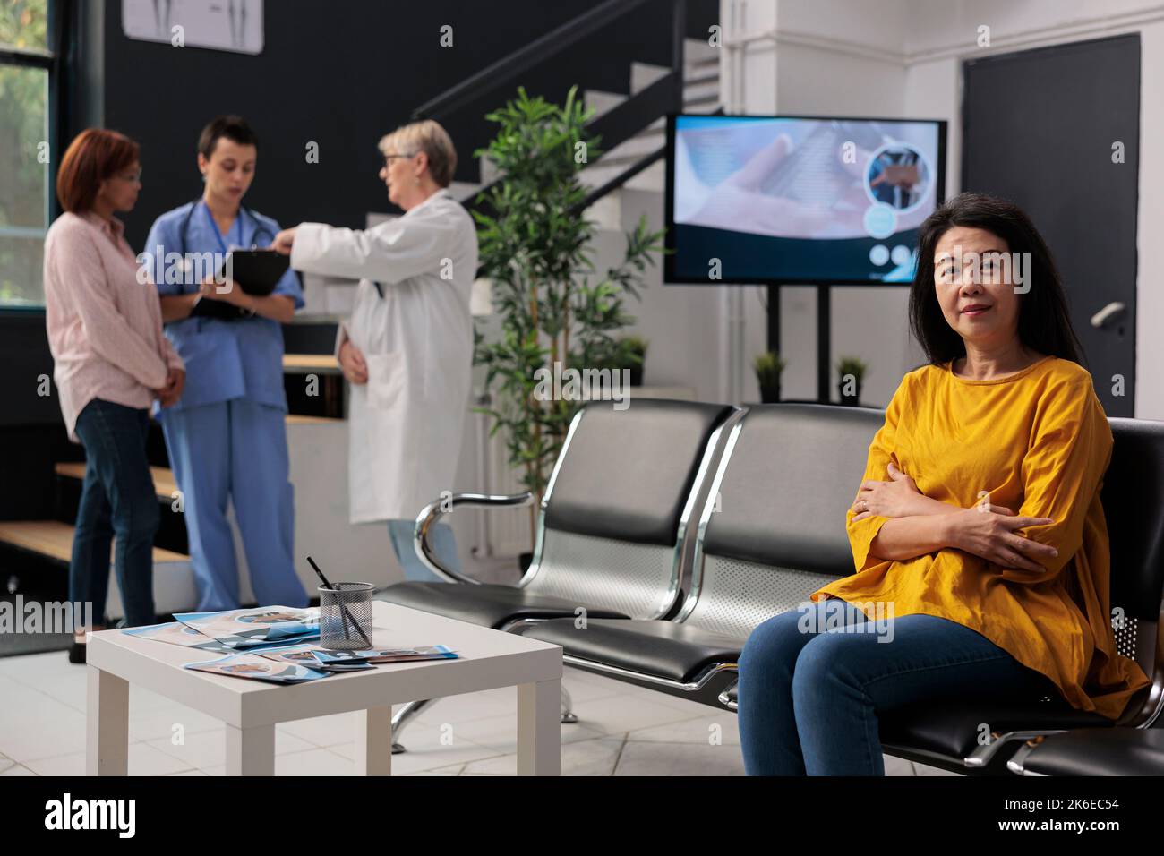 Portrait of injured woman waiting to attend checkup visit with medical staff, sitting in ...