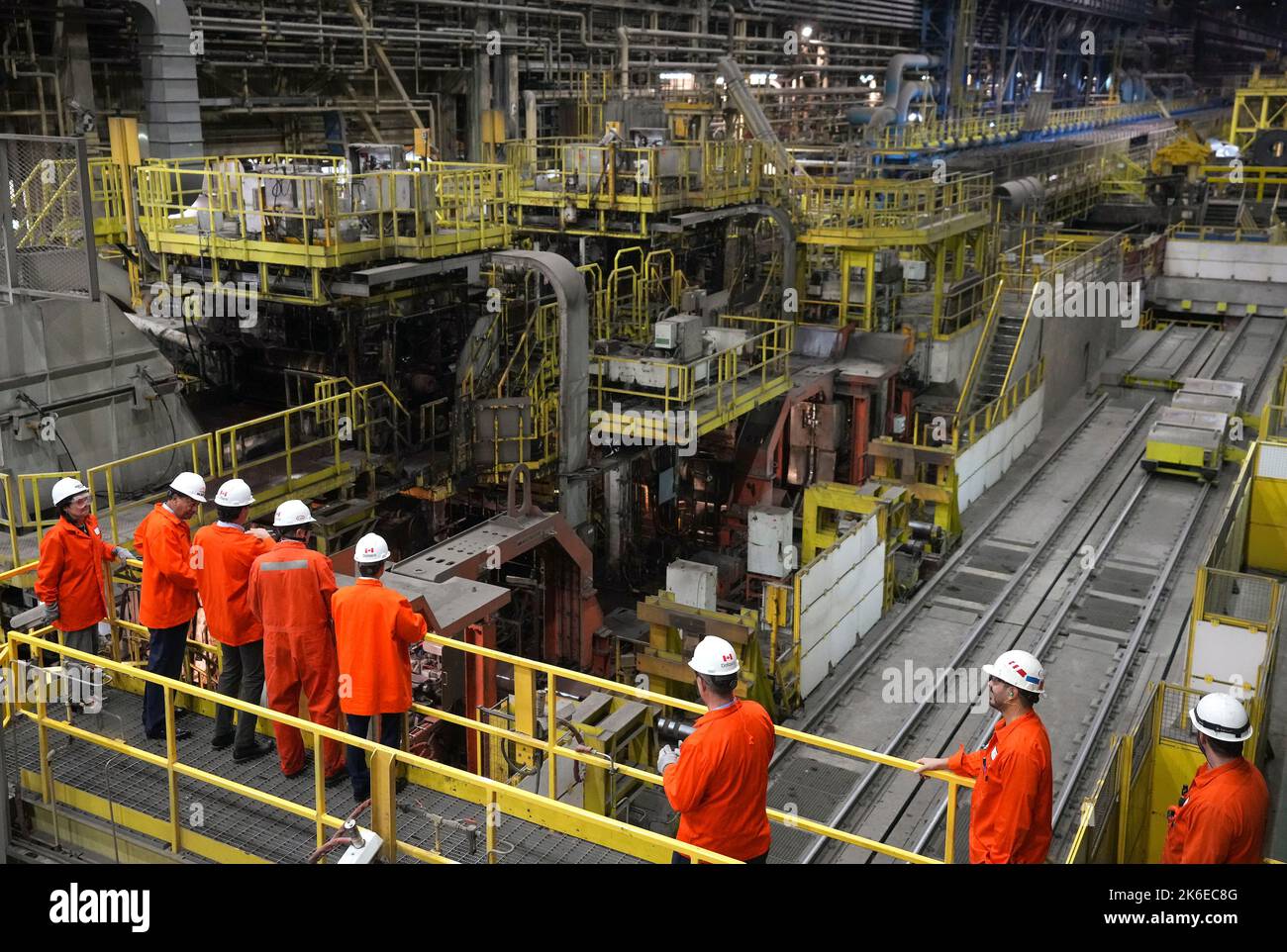 Employees at ArcelorMittal Dofasco, a manufacturer of hot rolled steel coils, look on at a ...