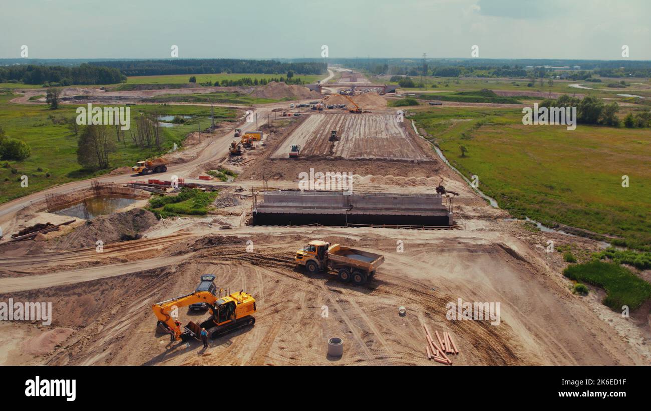 Heavy earthmoving machinery on a huge road construction site. Long ...