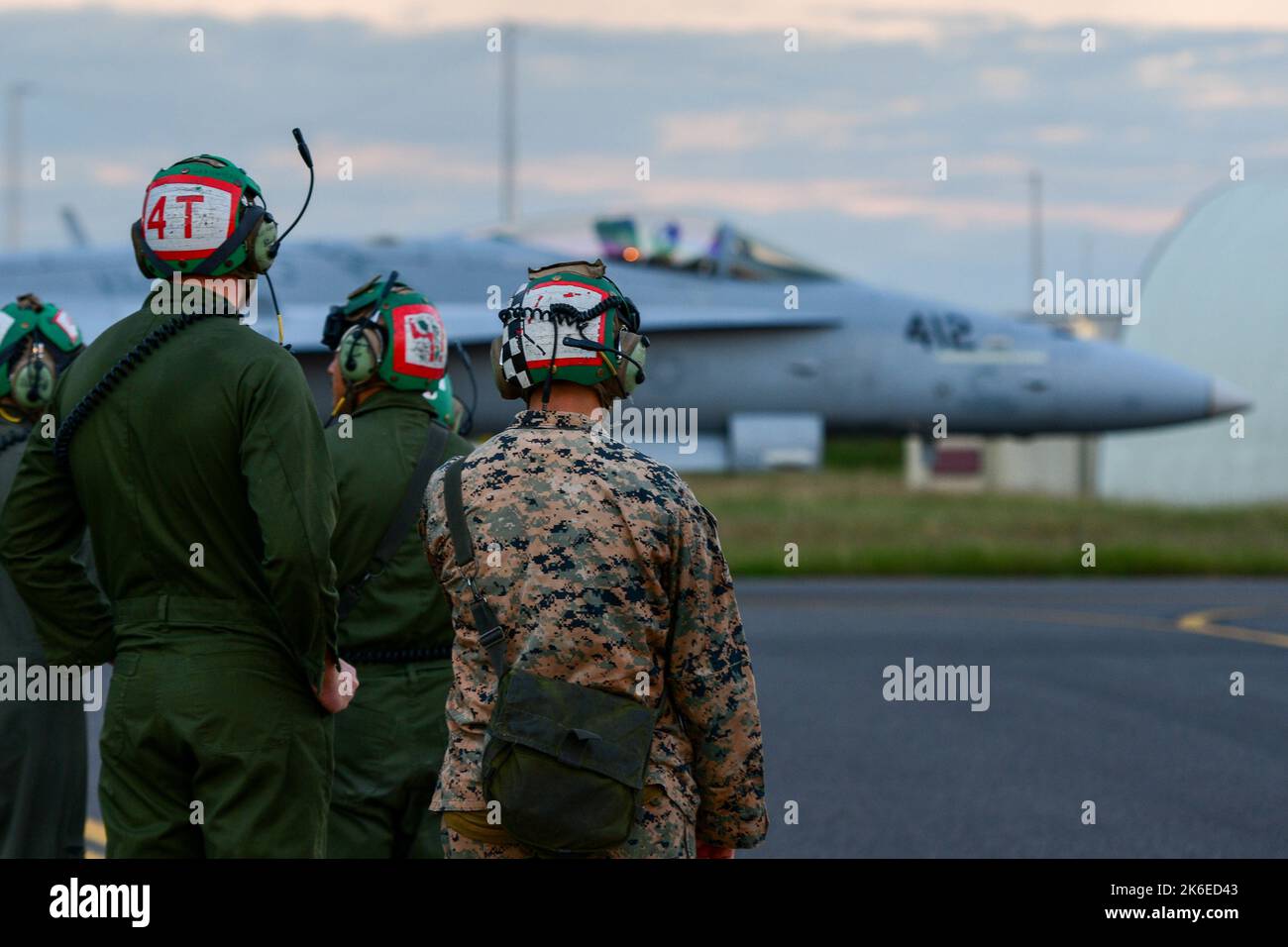 U.S. Marines watch as an F/A-18 Hornet assigned to the Marine Fighter ...